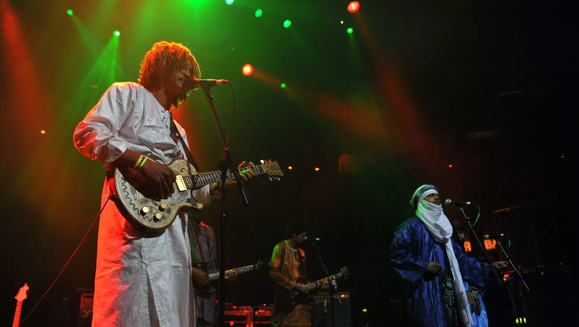 Ibrahim Ag Alhabib (kumanzere) ndi Abdallah Ag Alhousseyni wa ku Tinariwen akuimba pa siteji ku The Roundhouse pa November 16, 2014 ku London.